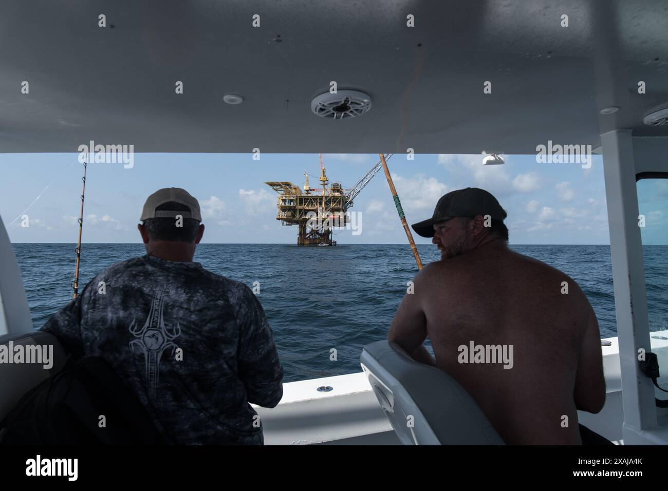 An angler reels in a tuna caught near floating oil rigs in the Gulf of ...