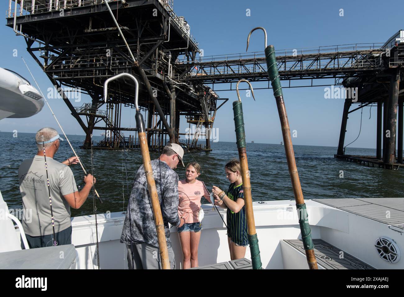 Anglers fish for baitfish while surrounded by offshore oil platforms in ...