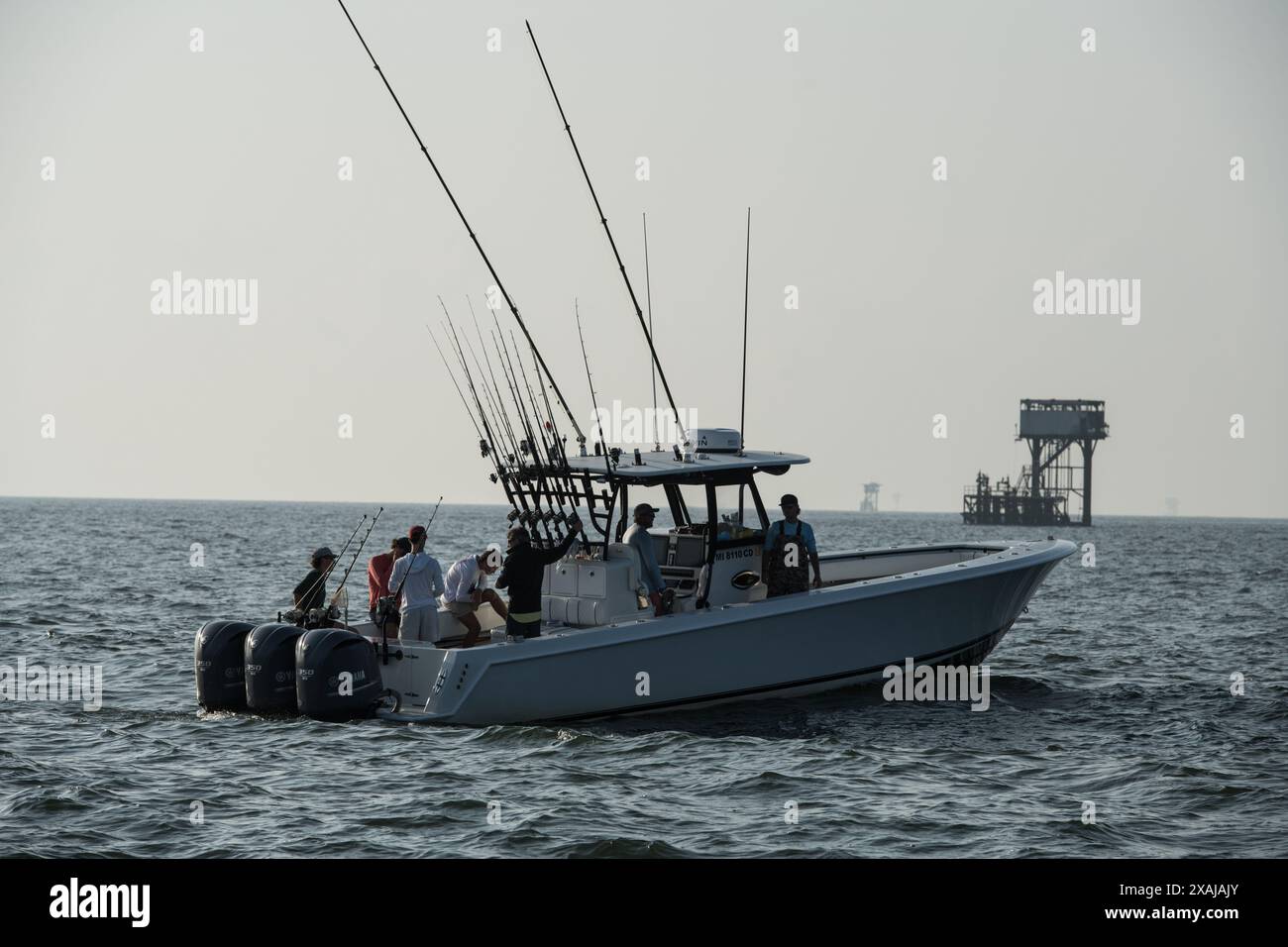 Anglers aboard a fishing boat near offshore oil rigs in the Gulf of ...