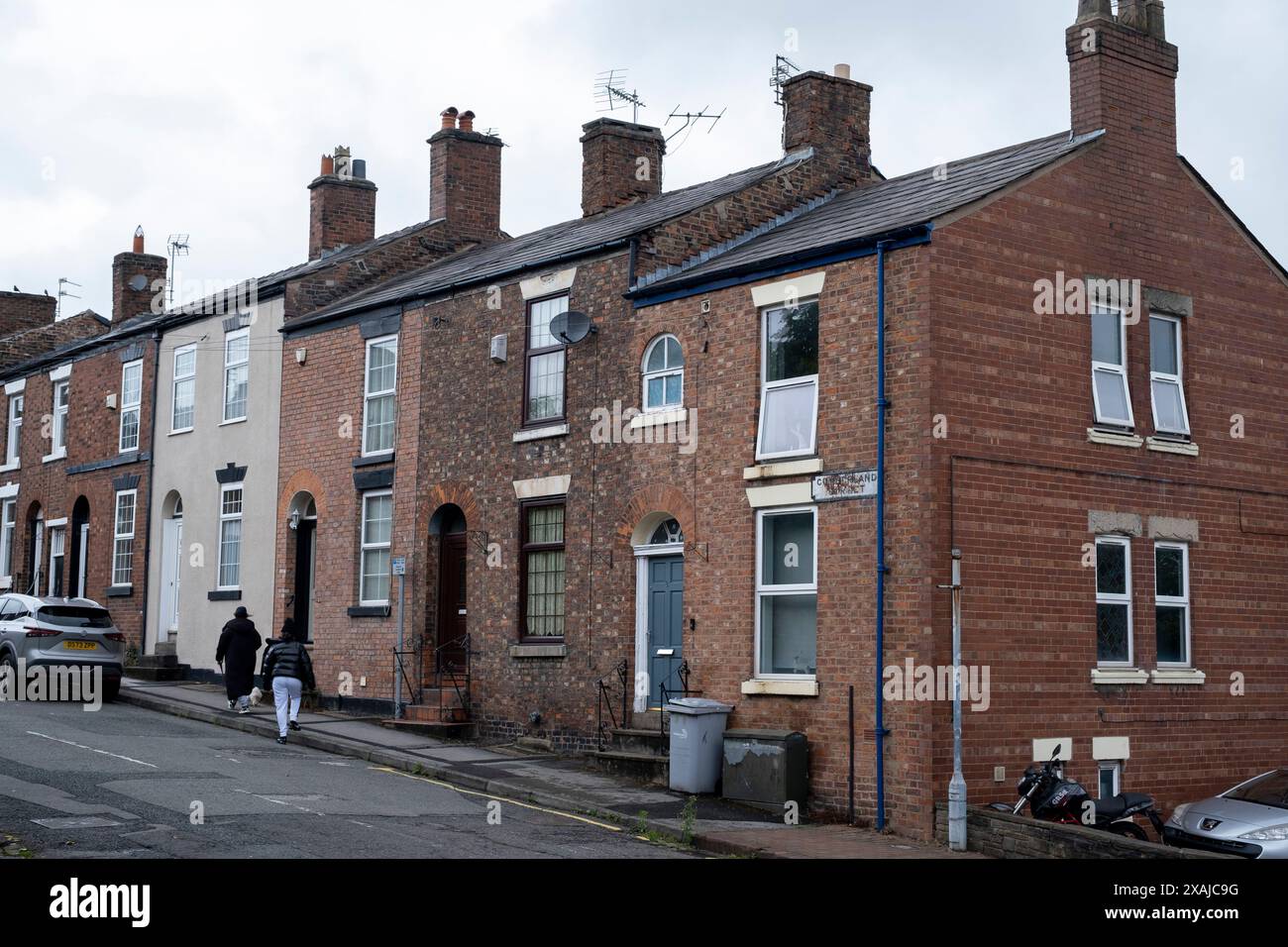 Row of red brick terraced houses with chimney pots on 30th May 2024 in ...