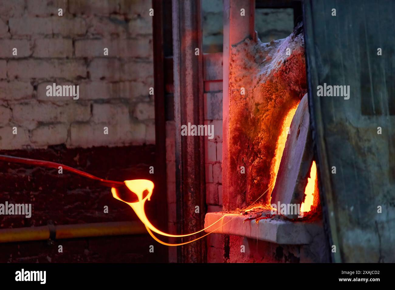 Murano glass-blowing factory. blower forming beautiful piece of glass ...