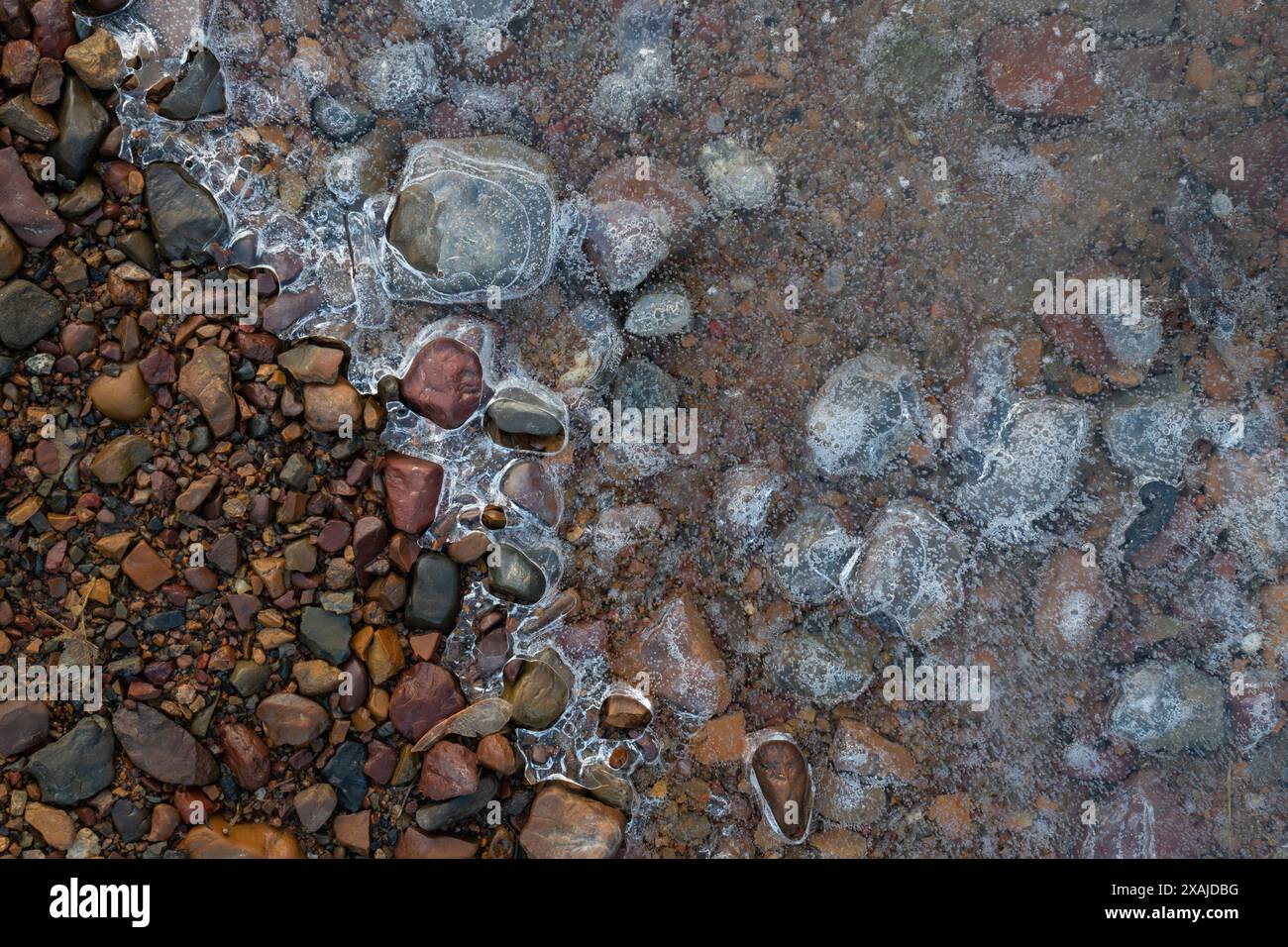 Frozen puddle on gravel, ice texture with air bubbles Stock Photo - Alamy