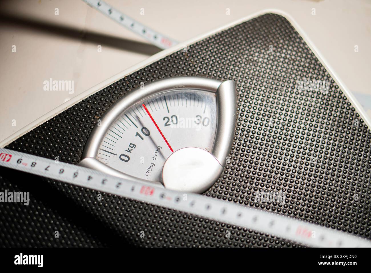 A close-up view of a mechanical bathroom scale with a measuring tape ...