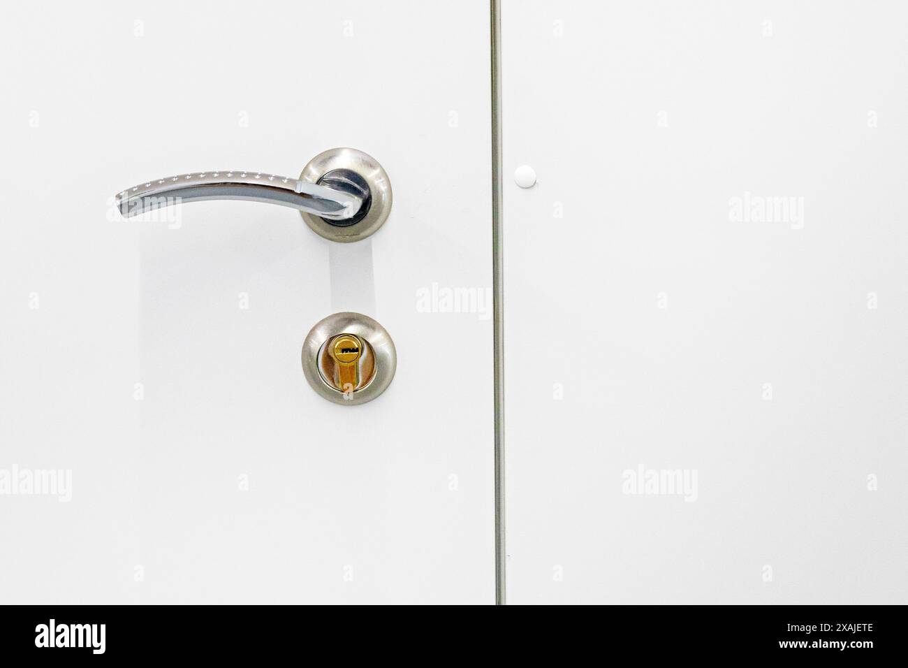 metal handle on a white closed door. Modern interior Stock Photo - Alamy