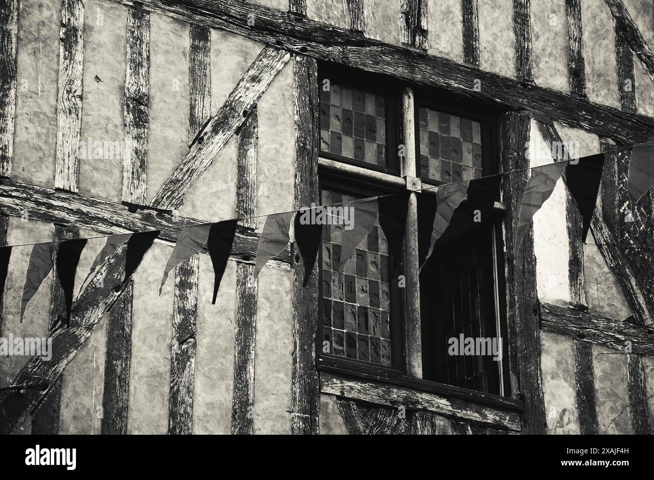 Street decorated with flags garland for medieval festival. Ancient half ...