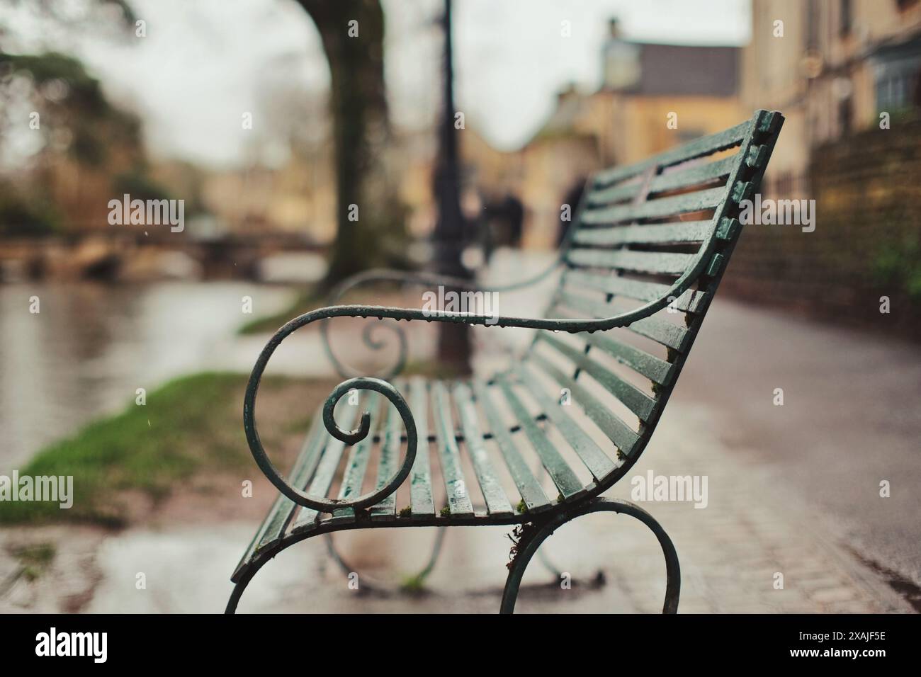Elegantly curved shaped bench in wet weather, taken in Bourton-On-The ...