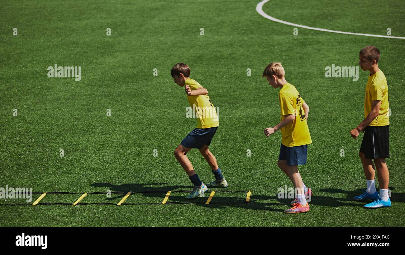 Boys in yellow uniforms training on outdoor football arena, practicing ...