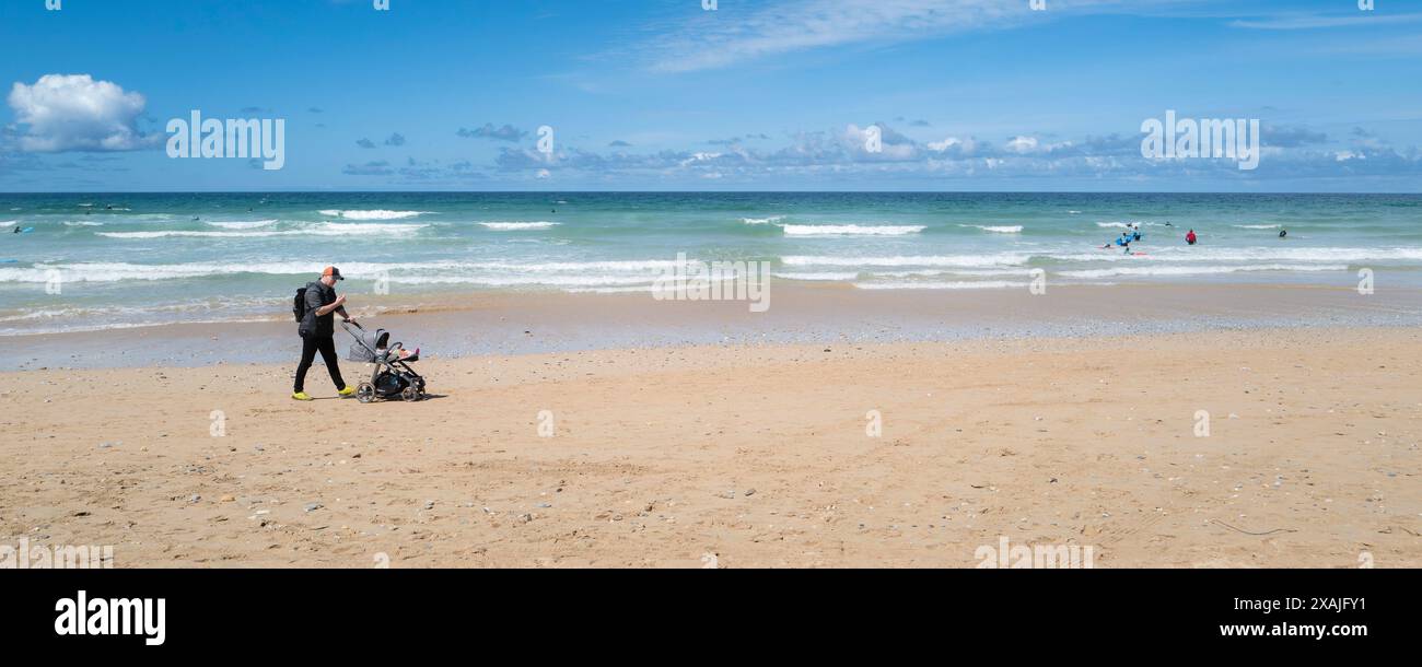 A panoramic image of a father pushing a stroller pushchair on Fistral ...
