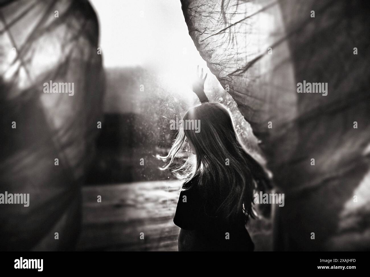 Young girl looking out window with curtains blowing Stock Photo - Alamy