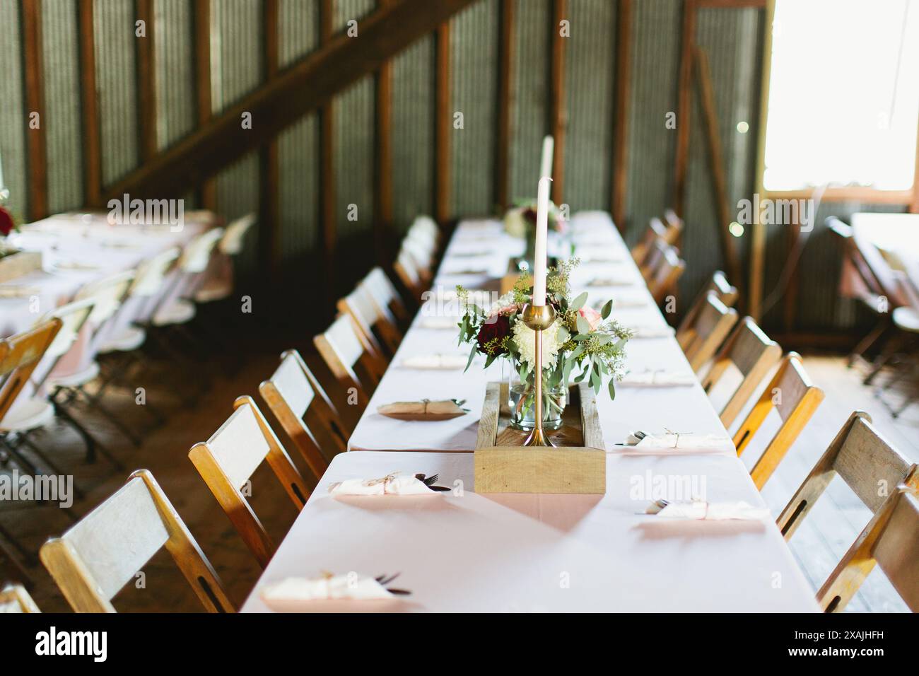 Barn wedding reception with flower centerpieces and candles Stock Photo ...
