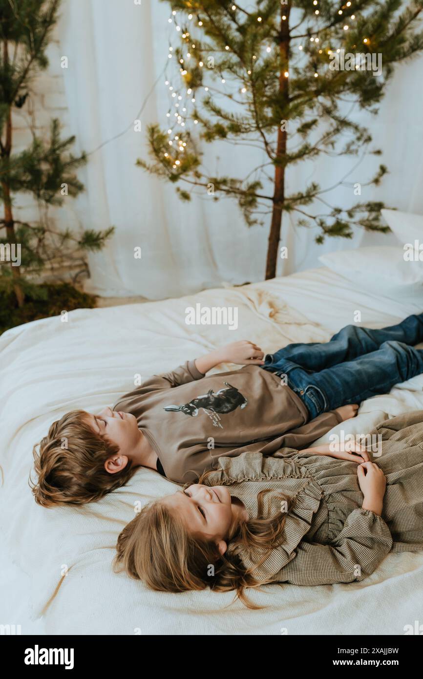 Two children laying on a bed Stock Photo - Alamy