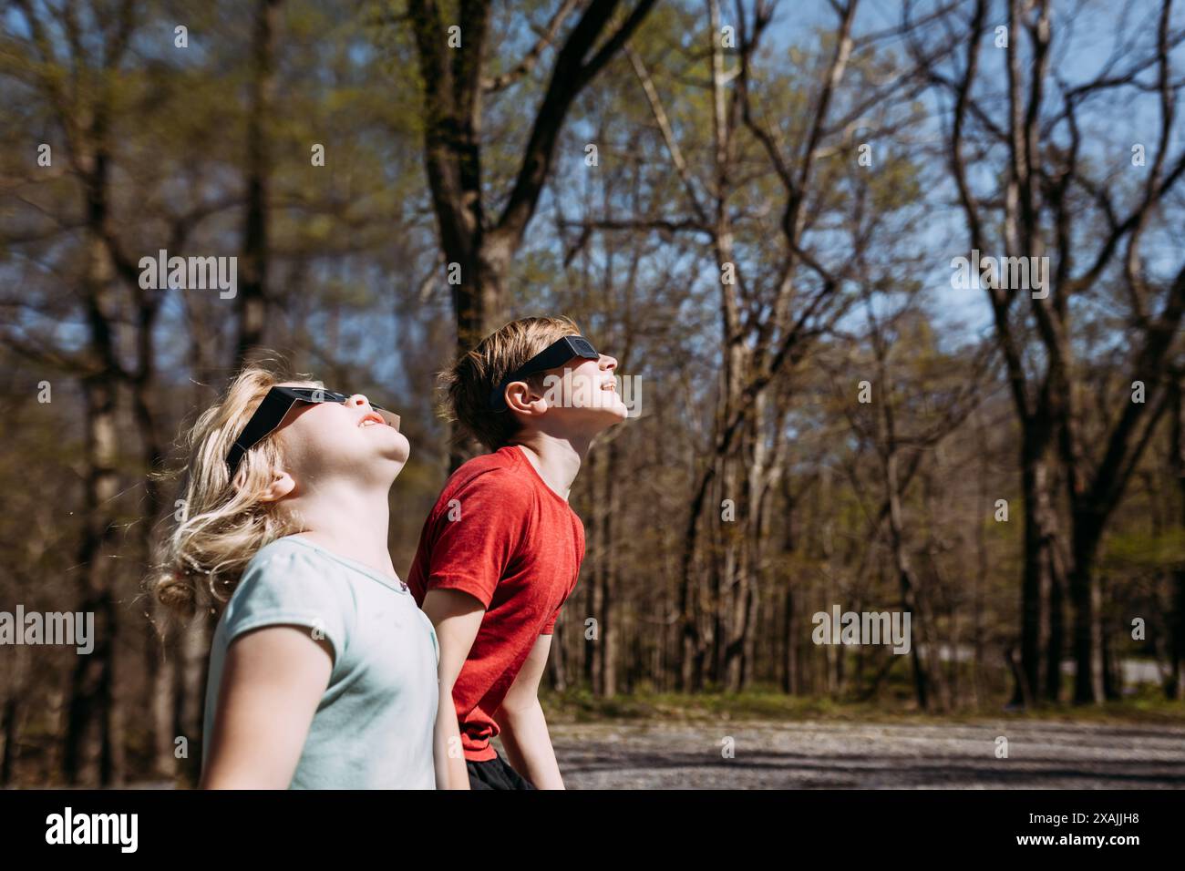 Children wearing solar eclipse glasses looking up at sun Stock Photo ...