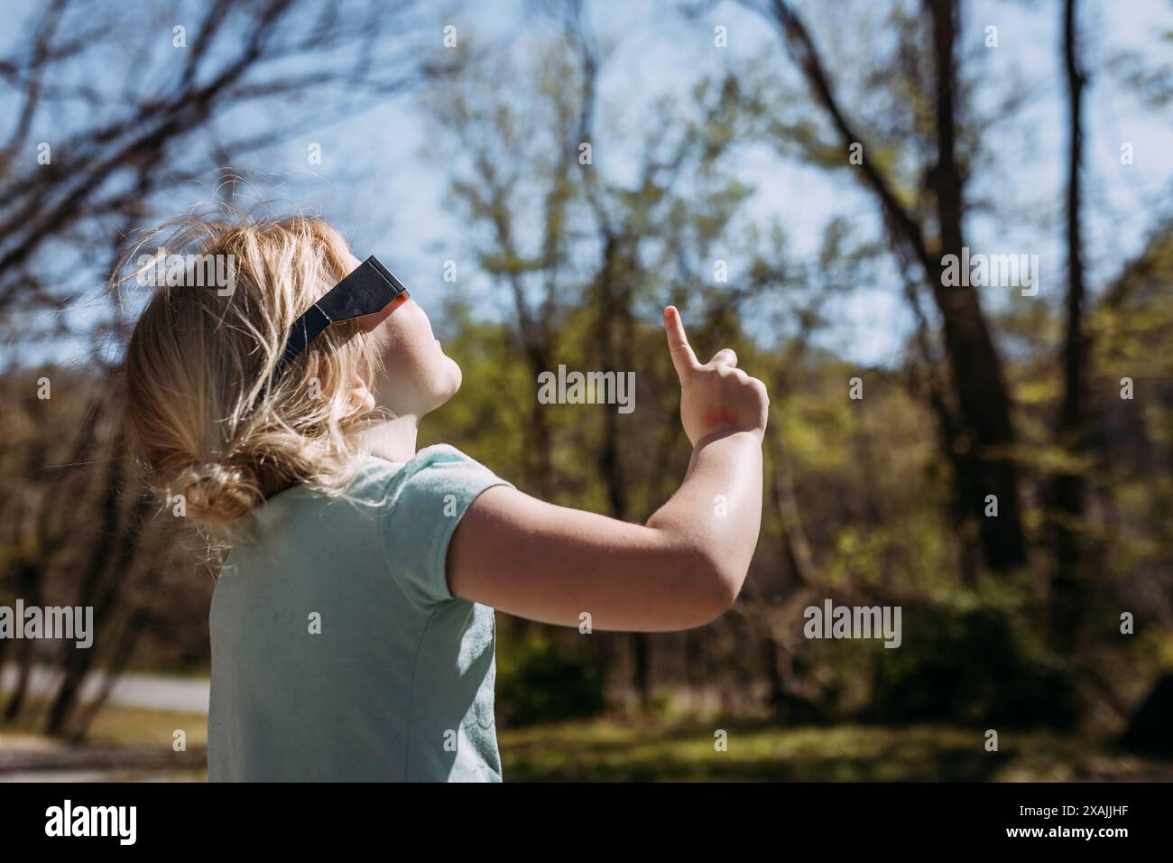 Child with solar filter glasses looking up at sun for solar ecli Stock ...