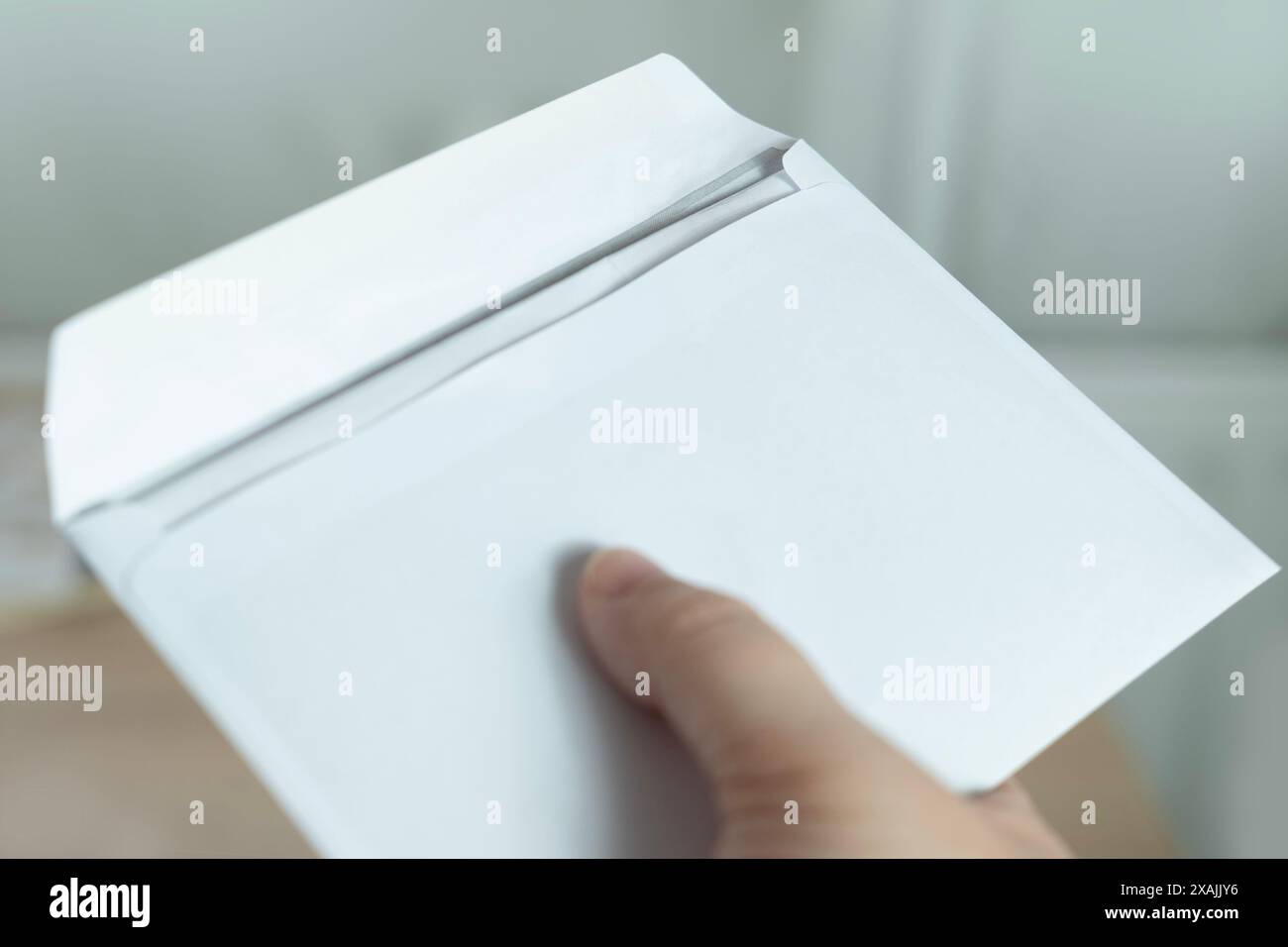 close-up shot of female hand holding white paper envelope, receiving ...