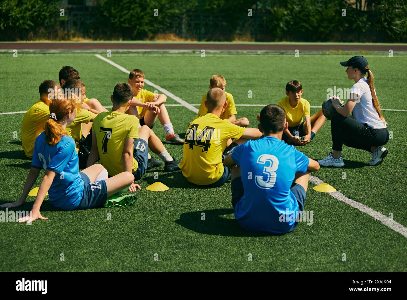 Active Youth Engagement. Children sitting on grass and listening to ...