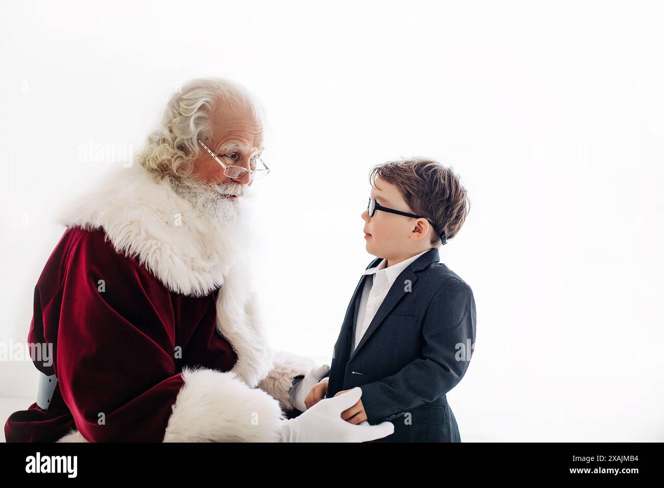 Santa talking to boy in suit with white background, close-up Stock ...