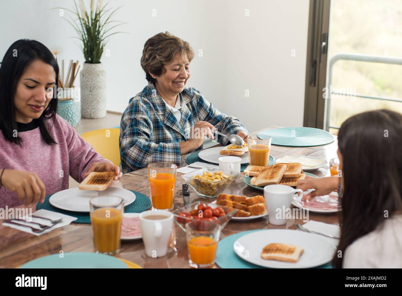 Three generations enjoying breakfast together in dining room Stock ...