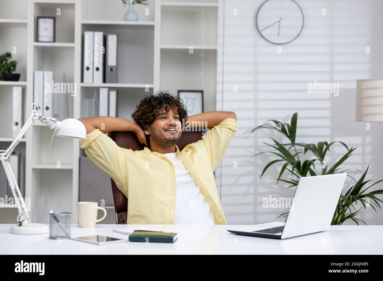 Young man in yellow shirt relaxing and smiling while taking a break at ...