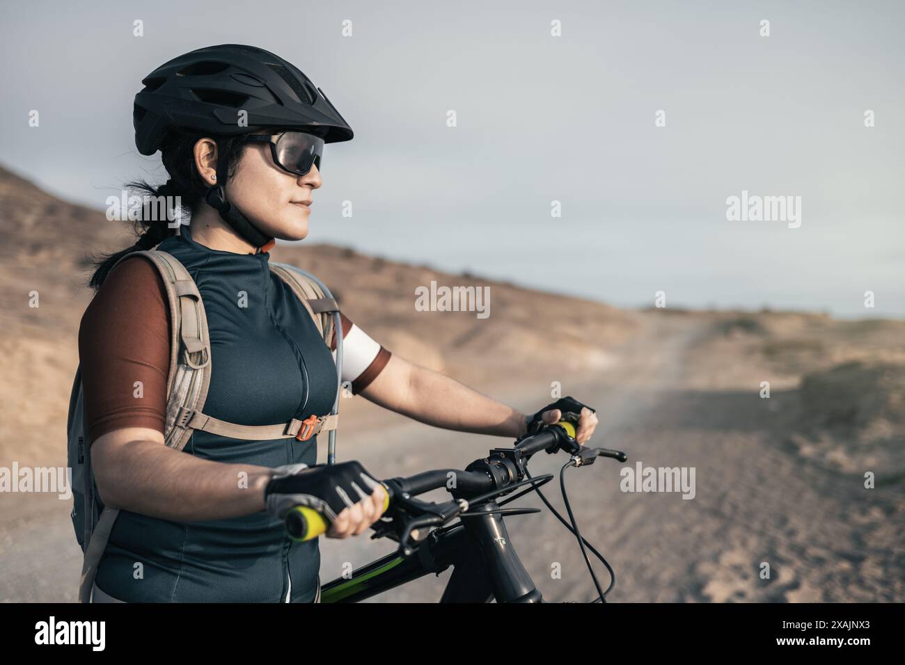 A woman stood enjoying the sunshine whilst out desert biking Stock ...