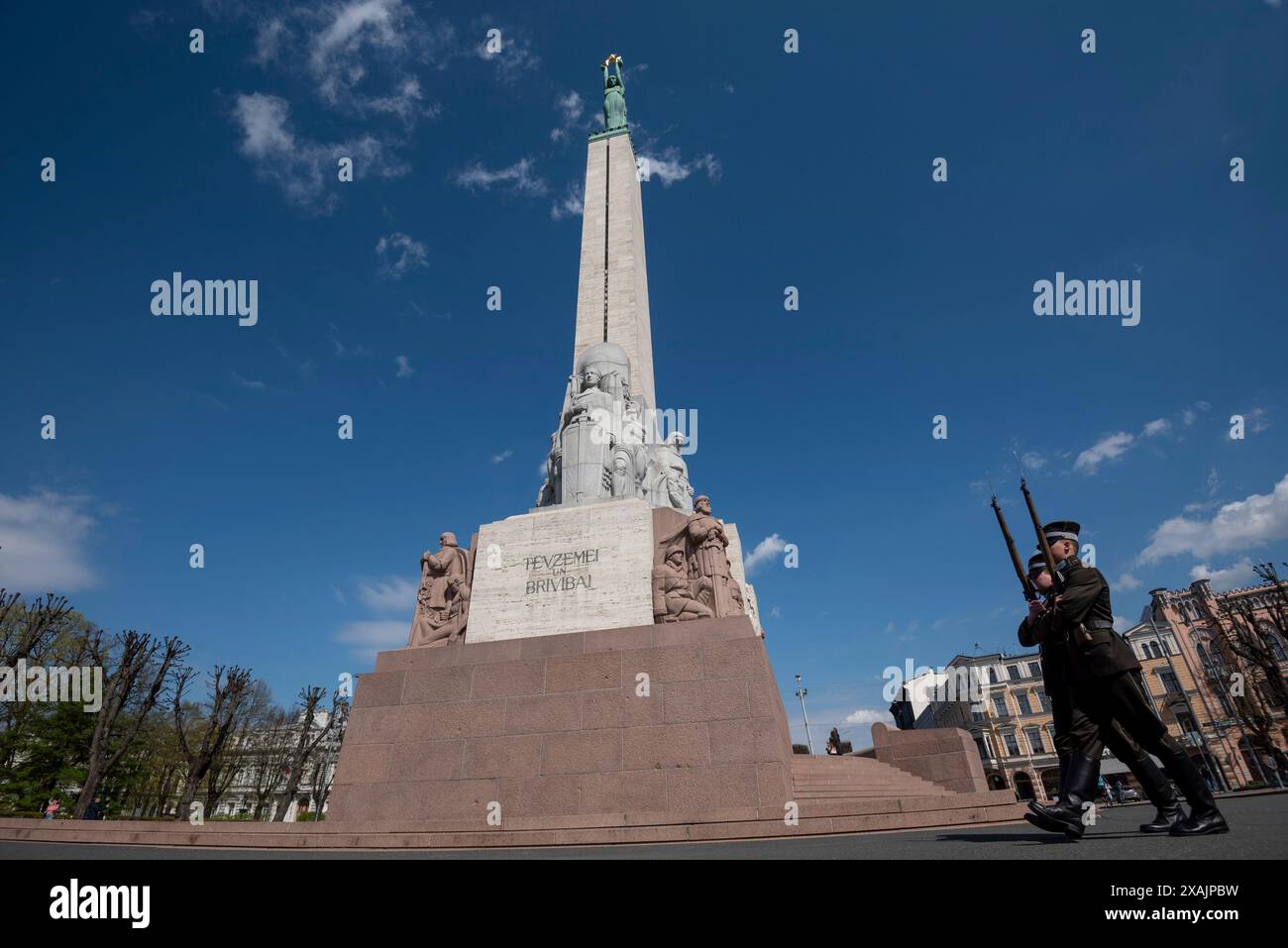 Two soldiers march in front of the Freedom Monument in Riga. The ...