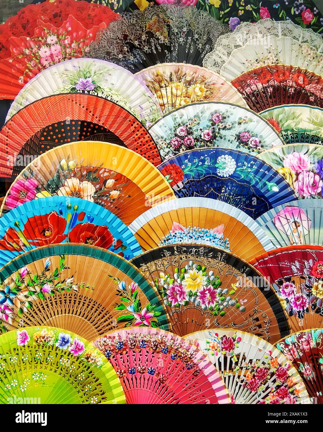 A collection of colorful fans with flowers and other designs. The fans ...