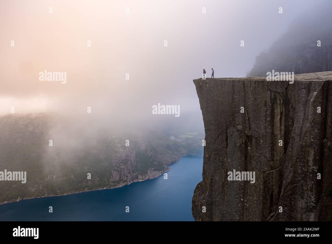 A breathtaking view of Preikestolen, a cliff in Norway, with two ...