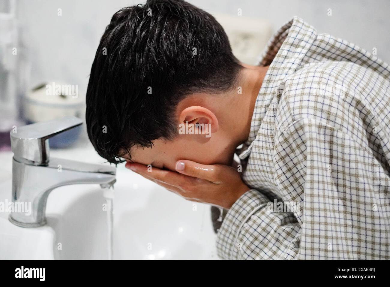 morning routine, boy in pyjamas washing his face in the bathroom Stock ...
