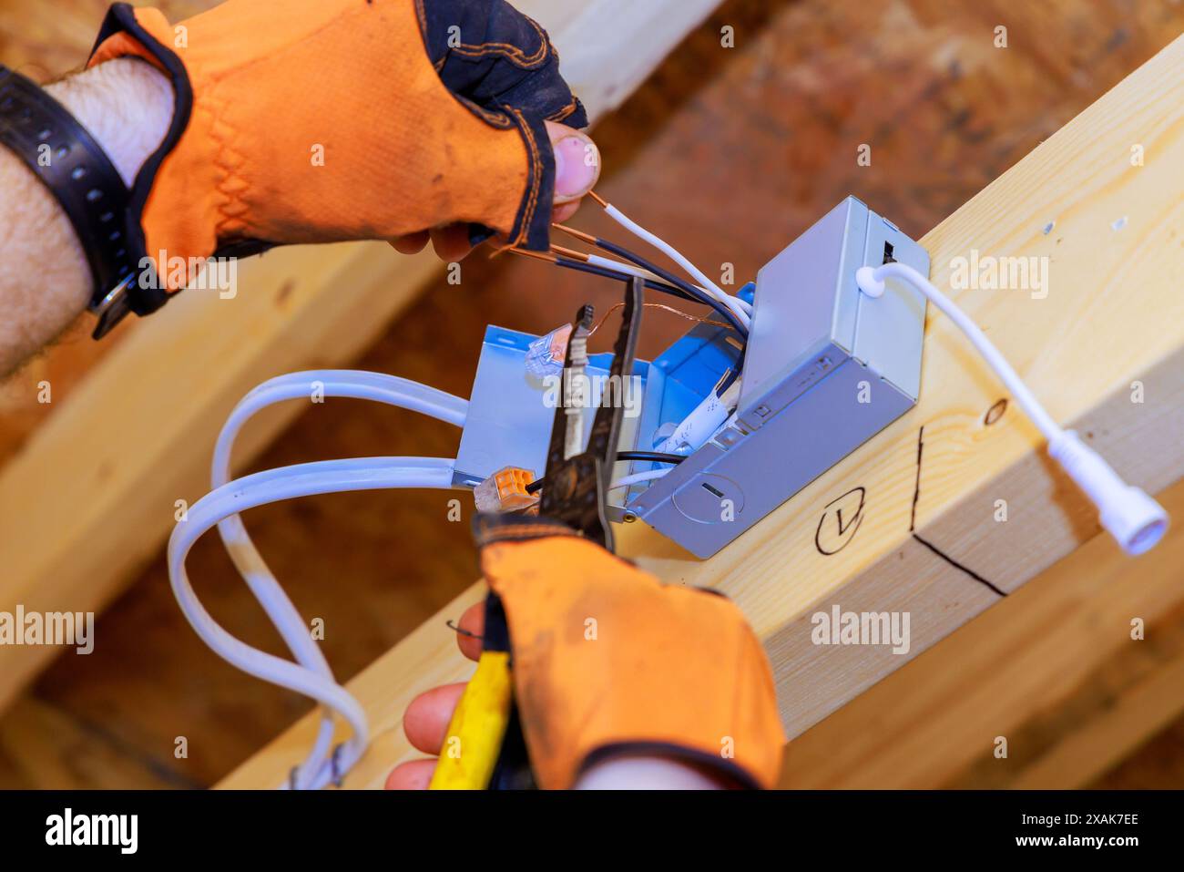 In new home construction, an electrician installs power junction box ...