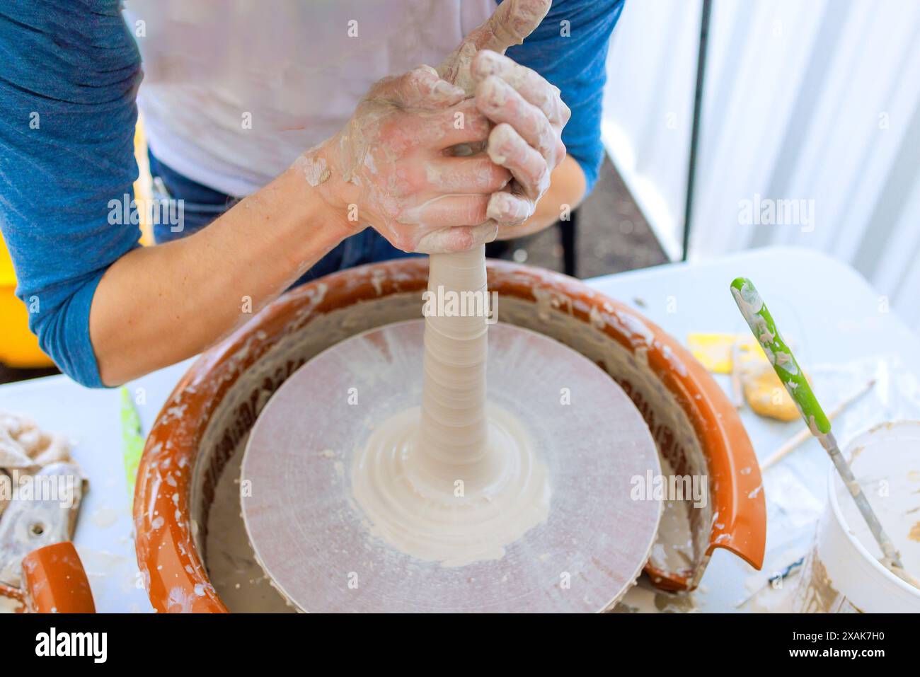 Clay dishes are crafted by potter who is hand sculpting soft clay with ...