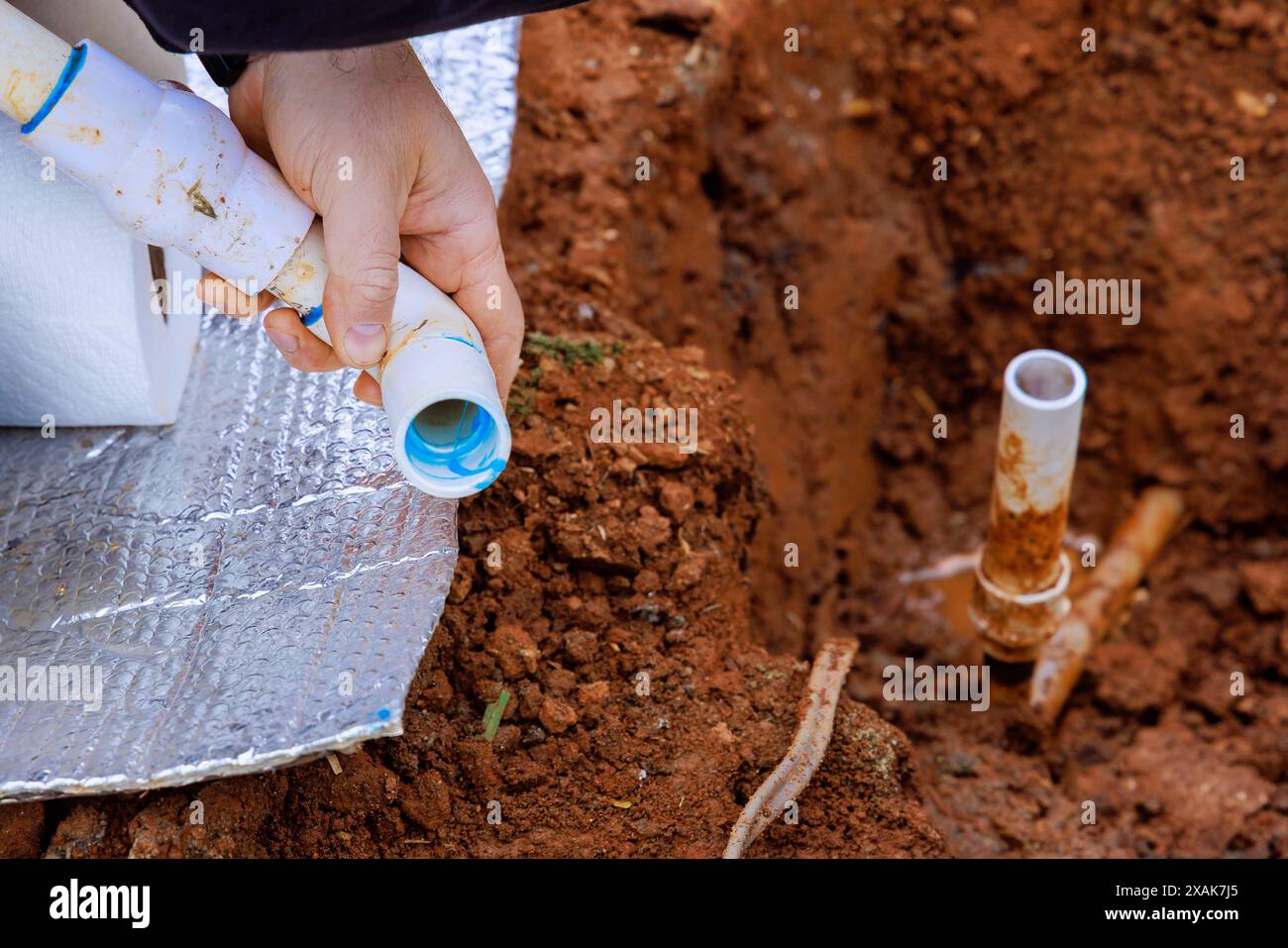 Attaching water supply to house by glue pvc pipes Stock Photo - Alamy