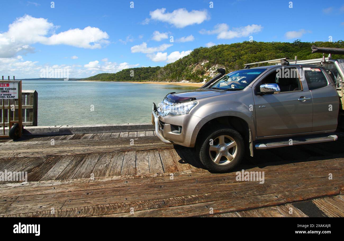 Cars waiting to embark on the Kingfisher Bay ferry on the wooden jetty ...
