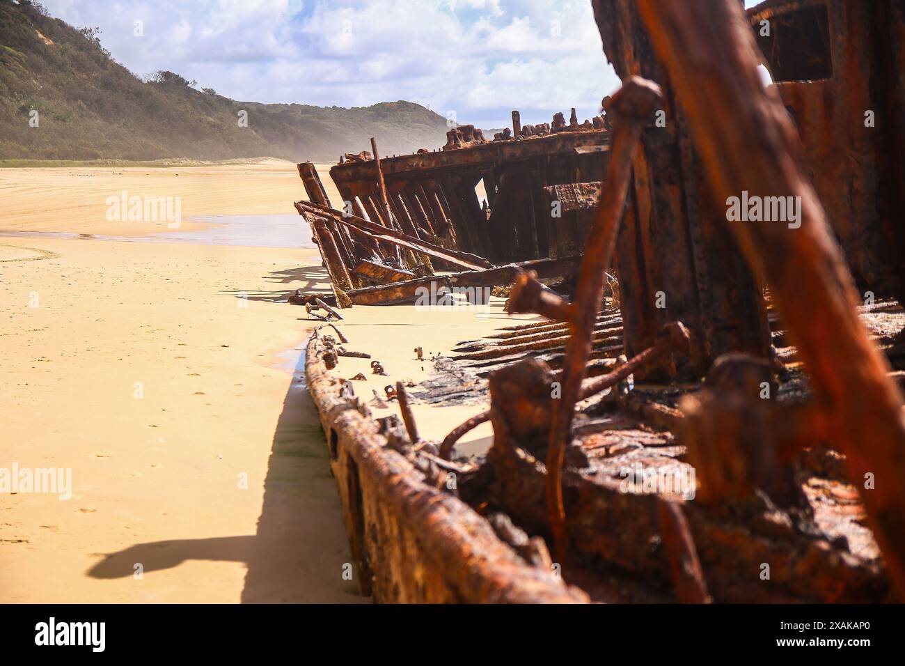 Rusty crumbling piece of the SS Maheno shipwreck half buried in the ...