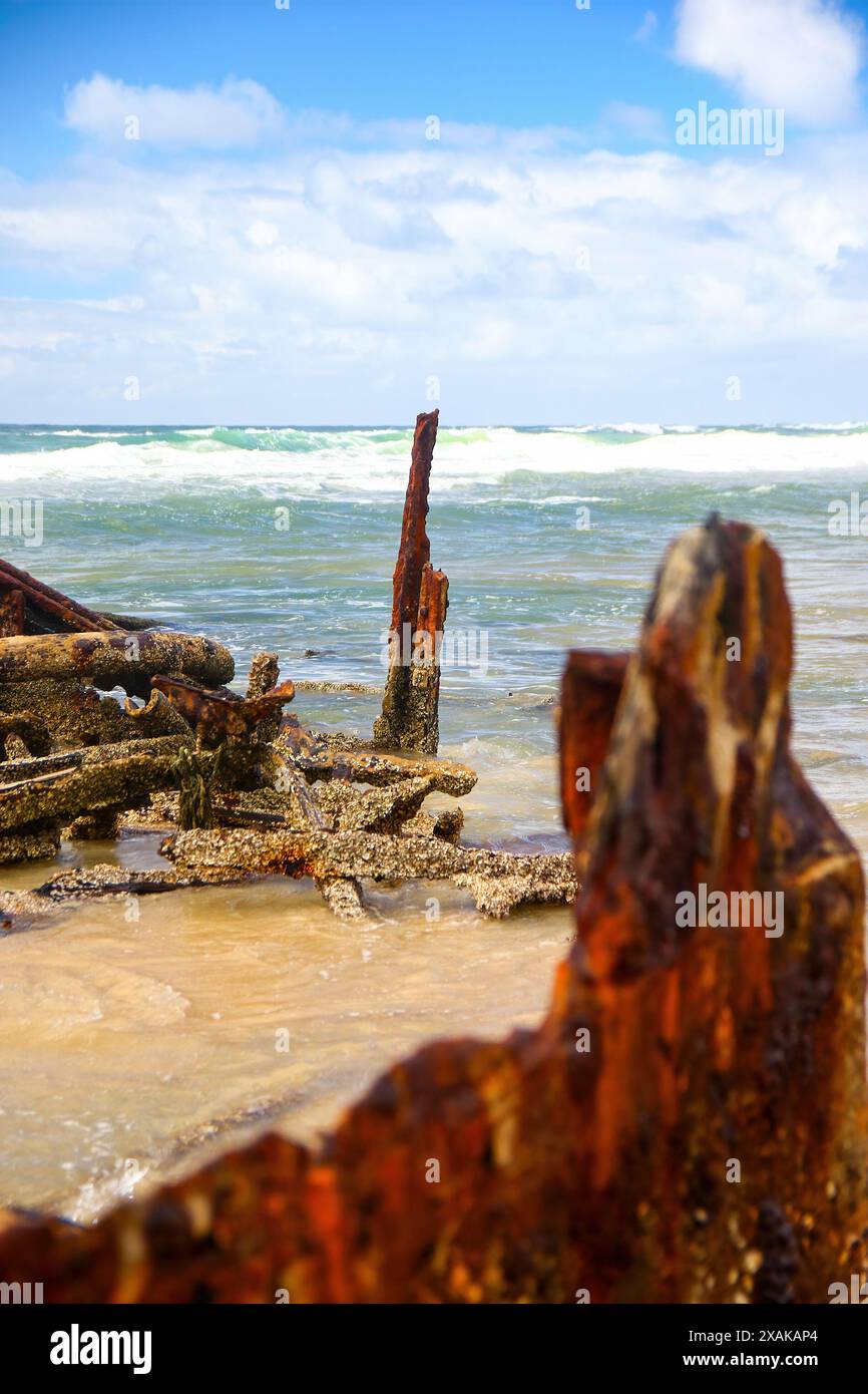 Rusty crumbling piece of the SS Maheno shipwreck half buried in the ...