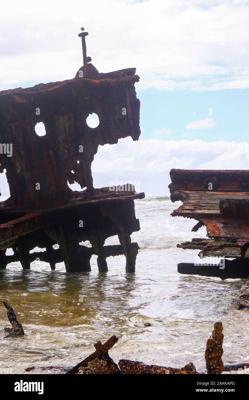 Rusty crumbling piece of the SS Maheno shipwreck half buried in the ...