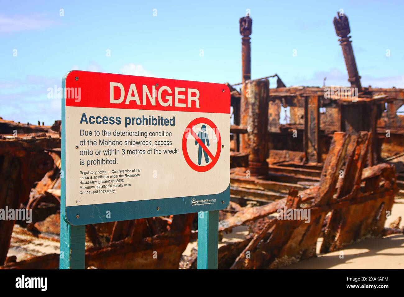 Danger sign prohibiting access to the SS Maheno shipwreck half buried ...