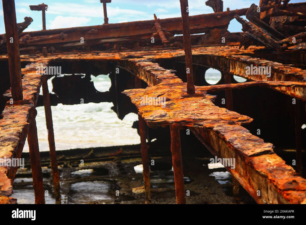 Rusty crumbling piece of the SS Maheno shipwreck half buried in the ...