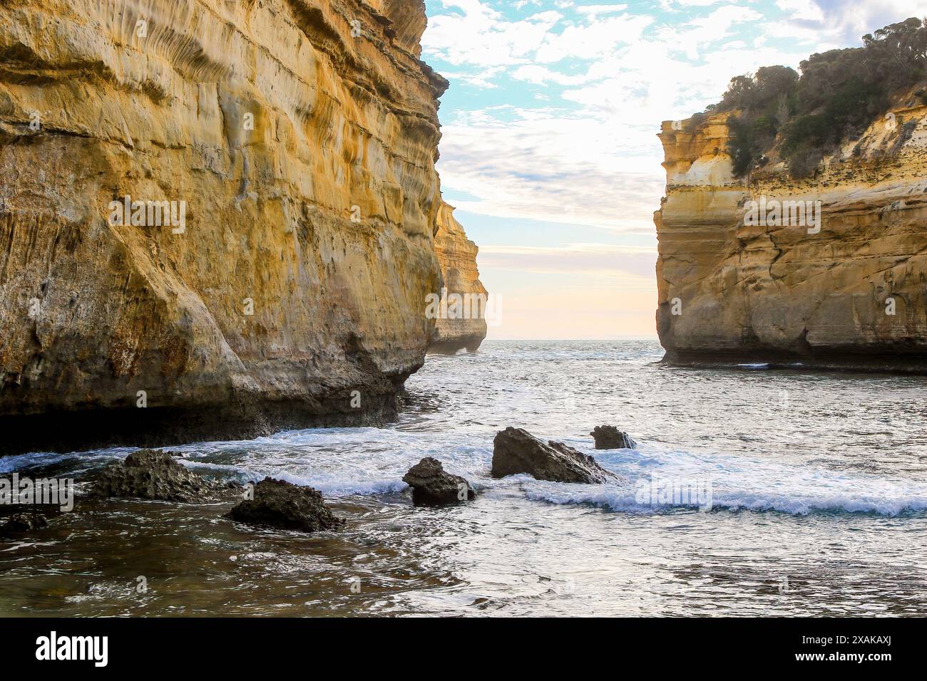 Waters of the Tasman Sea entering Loch Ard Gorge surrounded by ...