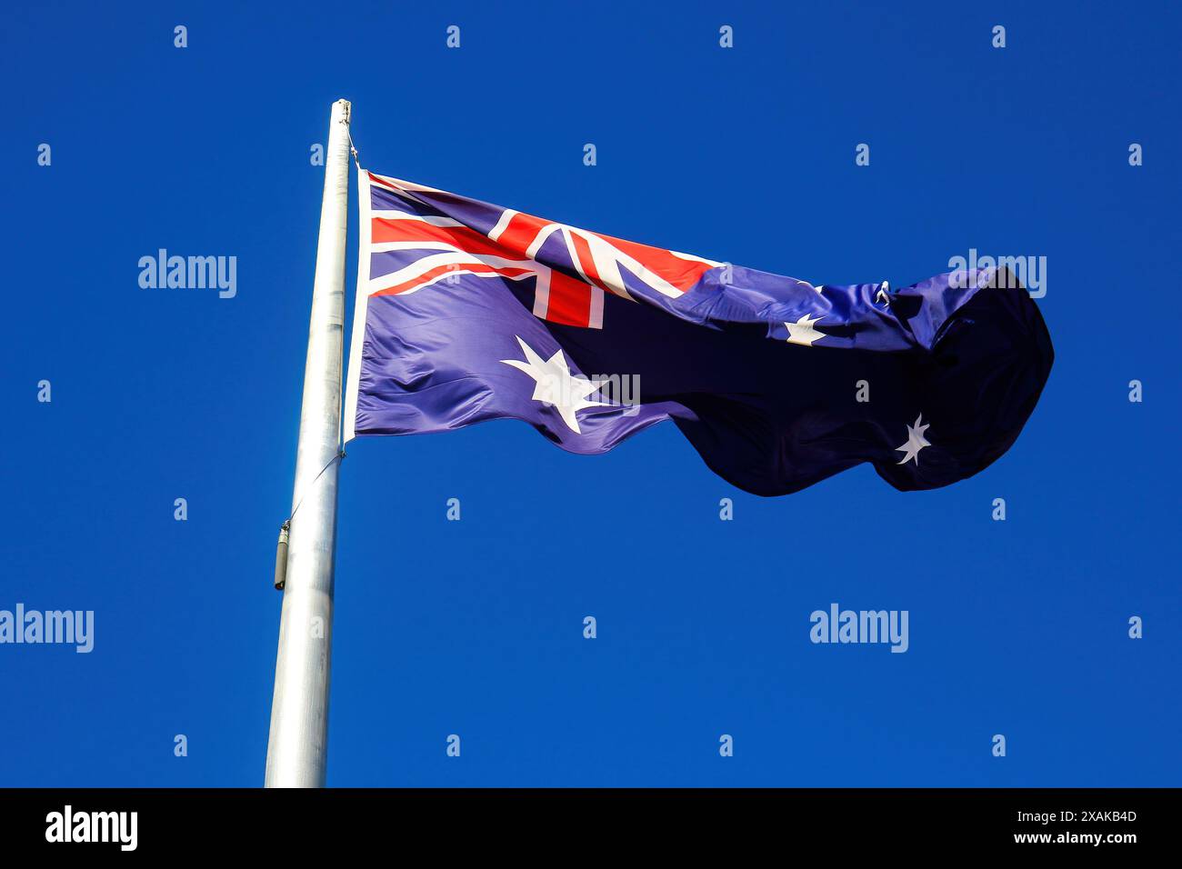 Australian flag floating in the wind at the top of a flagpole against a ...