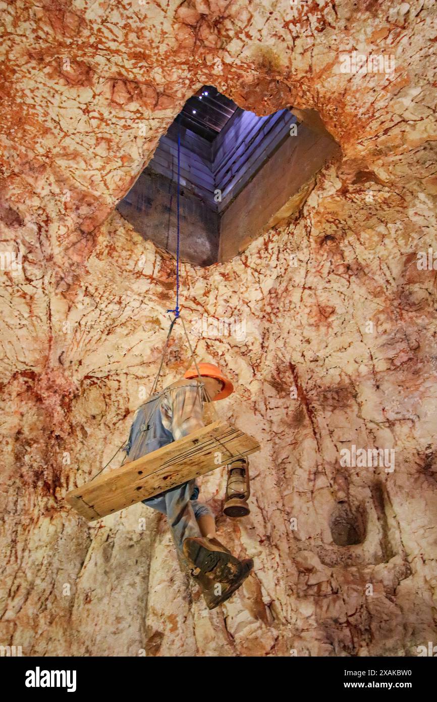 Miner suspended from a ventilation shaft in the underground Desert Cave ...