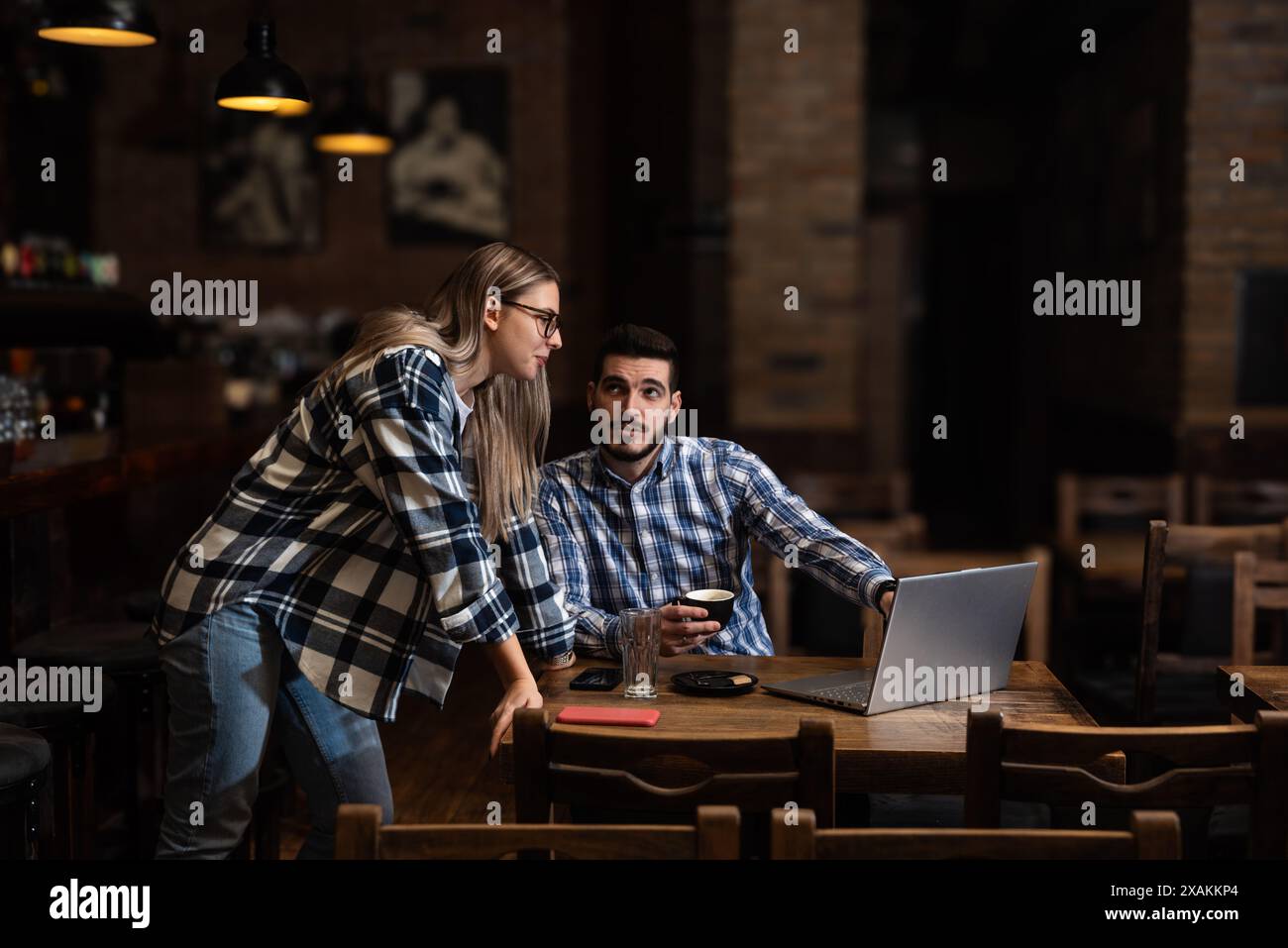 Two young people, husband and wife, Pub owners, working in their ...