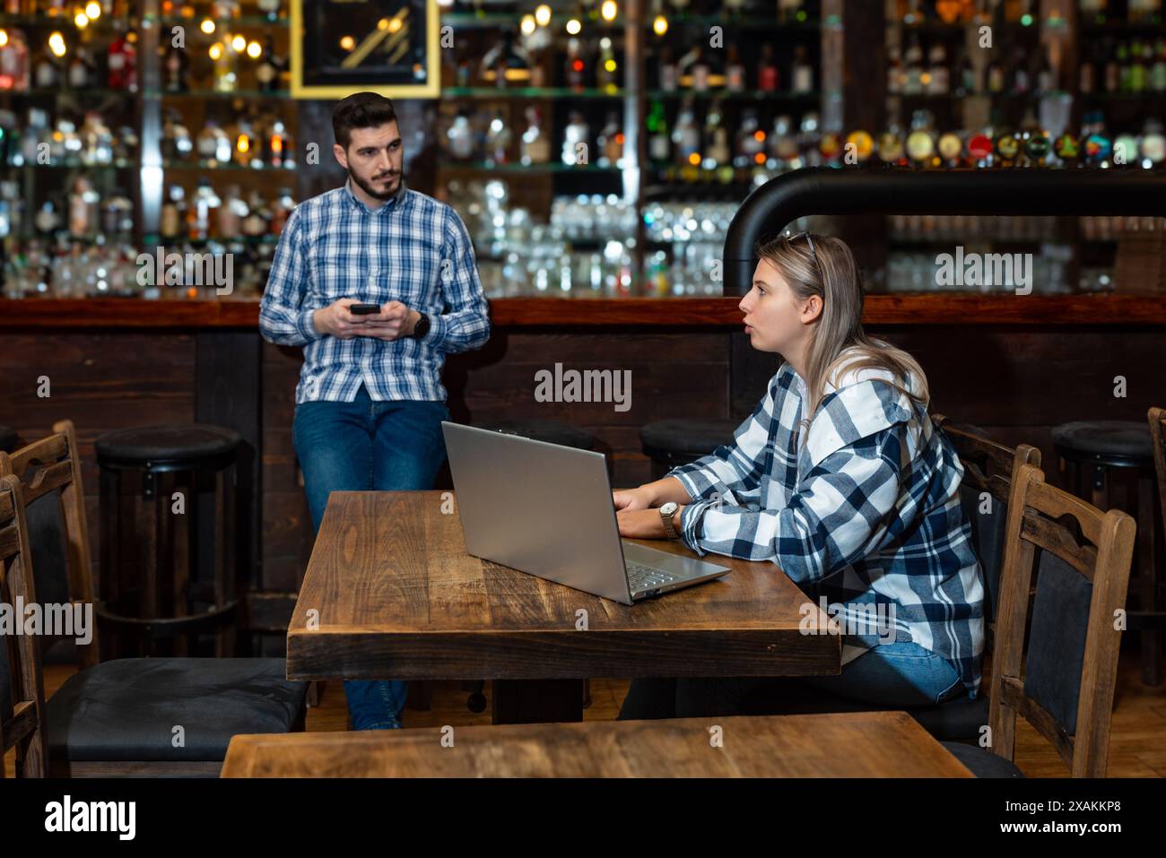 Two young people, husband and wife, Pub owners, working in their ...