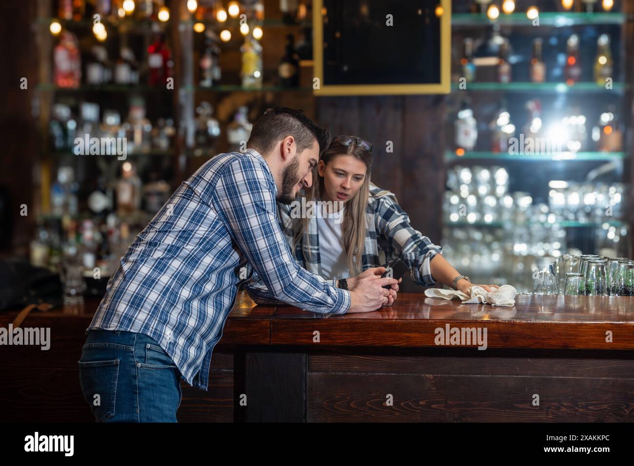 Two young people, husband and wife, Pub owners, working in their ...