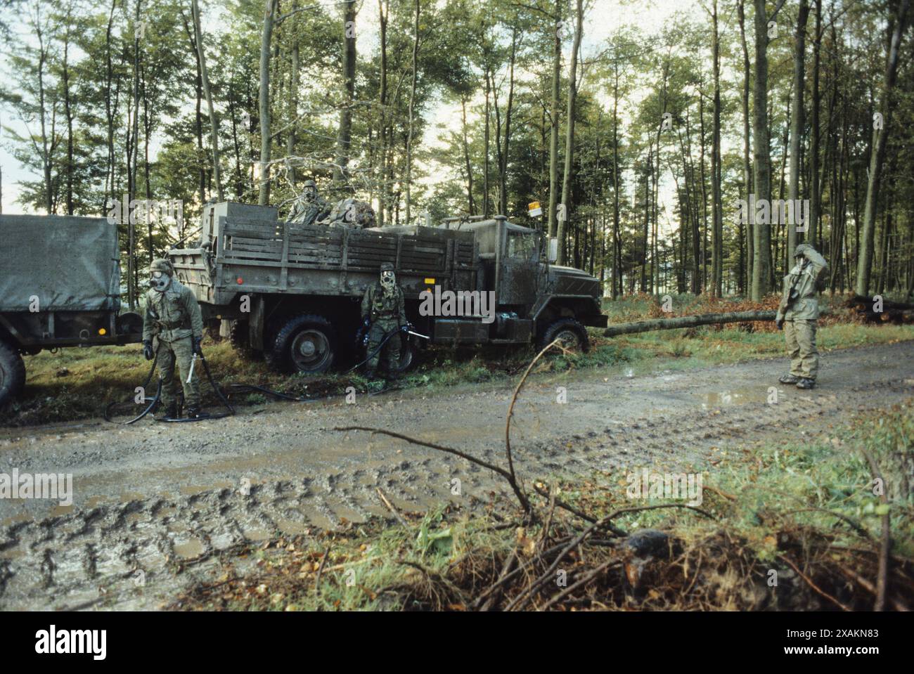 Tanker and 4 US soldiers with gas masks and protective clothing wait ...