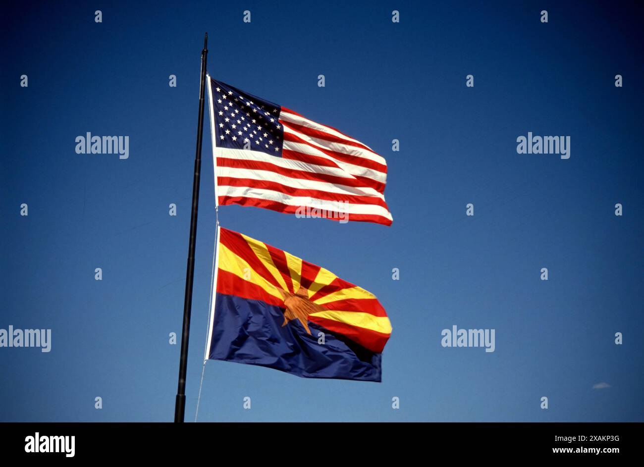 Flags of Arizona and United States waving in the wind on a clear day ...