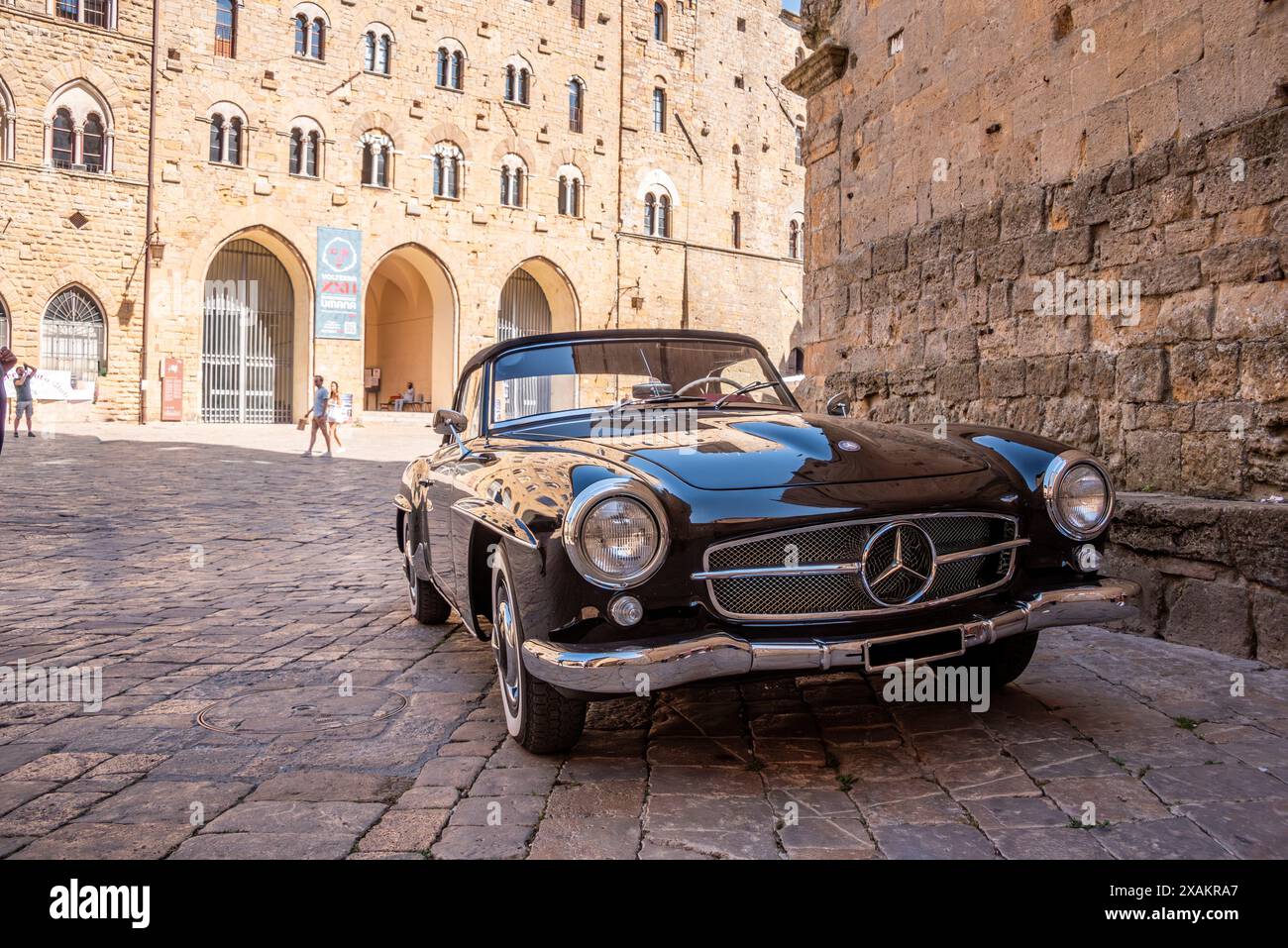 A Mercedes Benz 190SL vintage car in the town center of Volterra in the ...