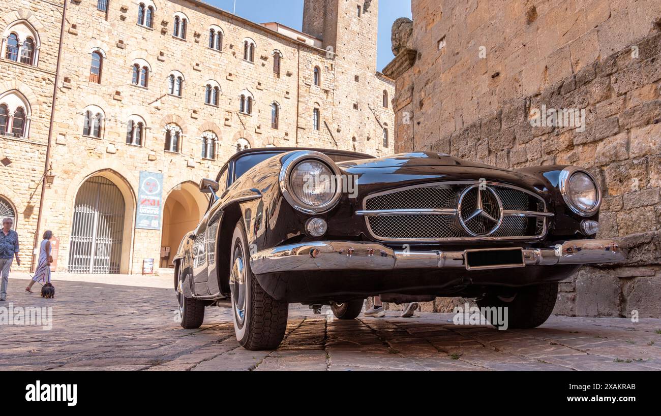 A Mercedes Benz 190SL vintage car in the town center of Volterra in the ...
