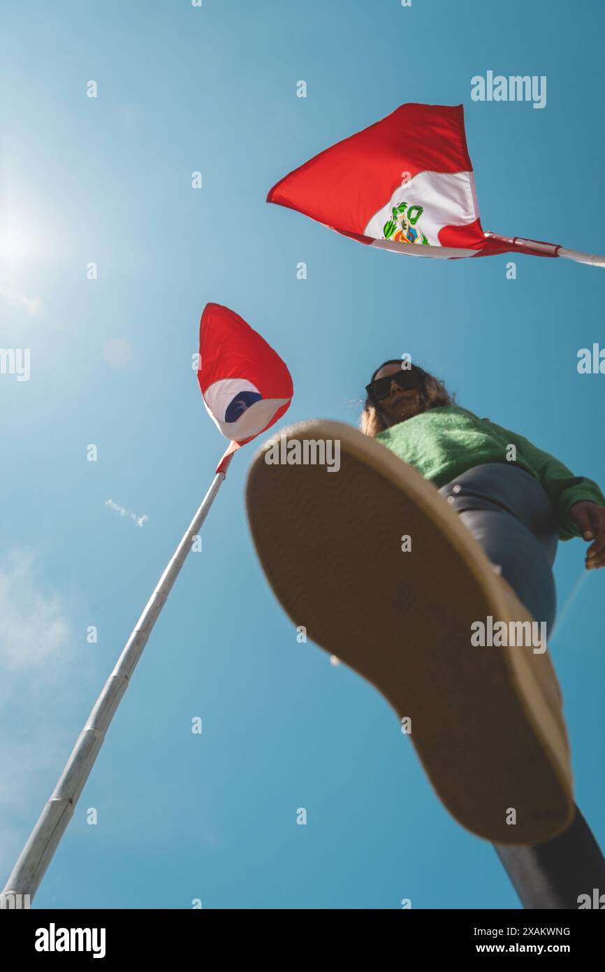 A woman walking at the border, the flags of Peru and Chile. Migration ...