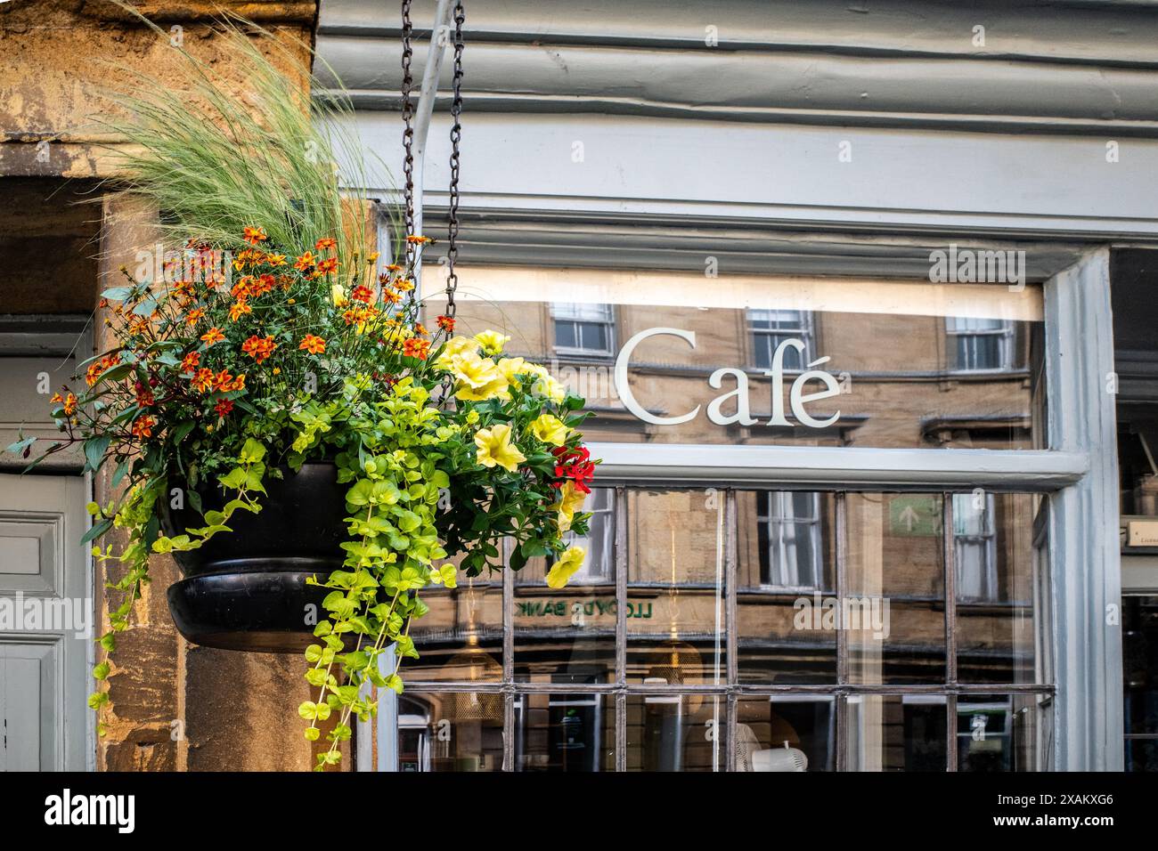 Reflections of Sherborne High Street in a cafe window, with a colourful ...