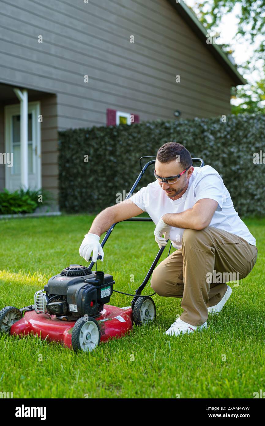 man using lawn mower outdoor. checking oil Stock Photo - Alamy
