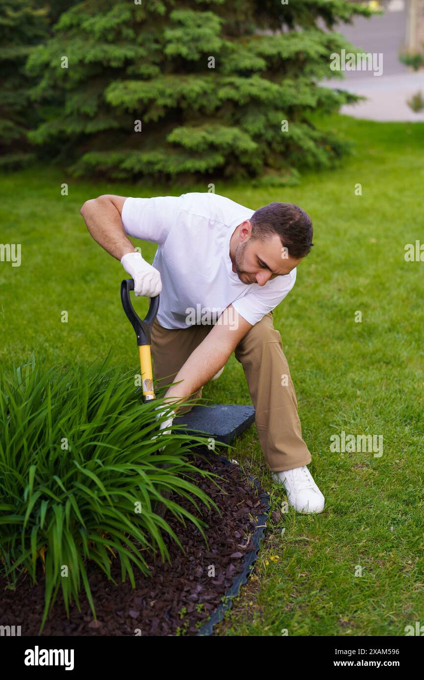 Gardener planting plants in the yard. Seasonal works in the garden ...